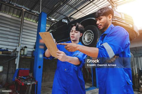 정비사는 고객을 위해 엔진을 검사하고 유지 관리합니다 수리 기계 자동차 서비스 및 유지 보수에 대한 체크리스트를 클립 보드에