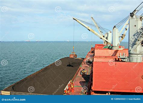Loading Coal From Cargo Barges Onto A Bulk Carrier Using Ship Cranes And Grabs At The Port Of