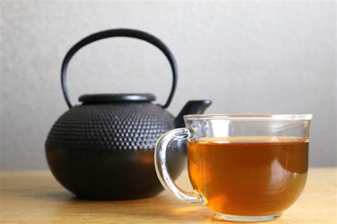 테이블에 검은 차 주전자 앞에 호박색 허브 차의 클리어 유리 컵 찻주전자에 대한 스톡 사진 및 기타 이미지 찻주전자 컵