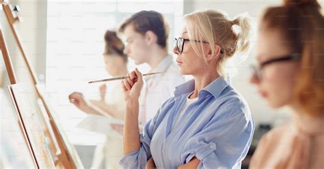 이젤에 그녀의 그림을 보고 있는 붓을 든 잠겨 있는 성숙한 금발 여자 사진 Unsplash의 미술 수업 이미지