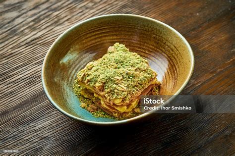 퍼프 페이스트리와 바닐라 슬라이스 또는 커스터드 슬라이스 피스타치오의 Ayers와 프랑스 디저트 밀feuille의 군침이 도는 조각 나무 배경에 접시에 제공 나폴레옹 케이크