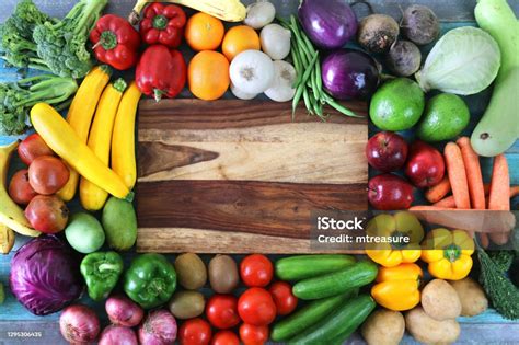 나무 도마 키위 녹색 피망 토마토 쿠르제트 붉은 양파 오렌지 석류와 고추 푸른 나무 곡물 배경 높은 전망에 전체와 반으로 반으로 된 과일과 야채의 그룹의 이미지 0명에 대한