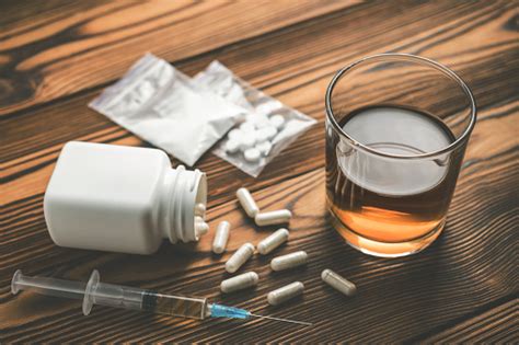 알코올 음료 위스키 또는 브랜디 흰색 알약 약물 복용량이 든 주사기 나무 테이블에 투명한 가방에 마약이 든 유리 중독과 나쁜 습관의 개념 0명에 대한 스톡 사진 및 기타