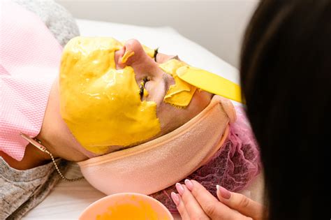 미용사 여성은 얼굴에 편안한 황금 마스크를 바르고 피부를 회복하고 보습합니다 2명에 대한 스톡 사진 및 기타 이미지 2명 건강관리와 의술 금색 Istock