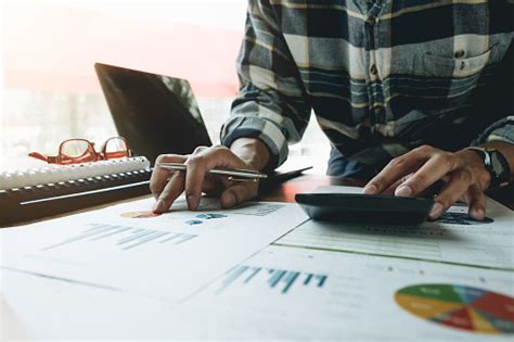 A 남자 금융에 대 한 작업 및 분석 비즈니스 문서 계산기와 계산 비용 회계 개념을 그의 사무실에 들고 안경 개념에 대한 스톡