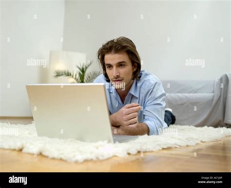 Man Lying On Floor Using Laptop Stock Photo Alamy