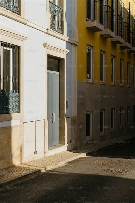 파란색 문과 창문이있는 노란색 건물 사진 Unsplash의 거리 이미지