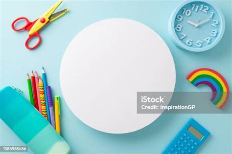 학교 준비는 산들 바람입니다 상단보기 문구류 필통 펜 플라스틱 계산기 가위 알람 시계 빈 원이있는 고요한 파스텔 블루 표면에 배열되어 텍스트 또는 광고에 이상적입니다 알람