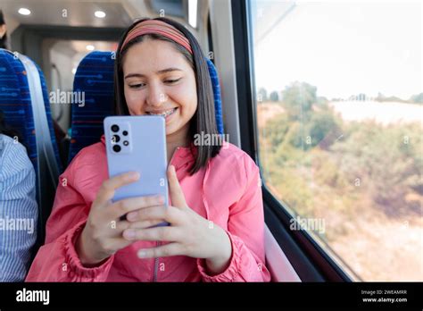 Young Smiling Latina Female Passenger Taking A Photo While Enjoying Traveling In Train Public