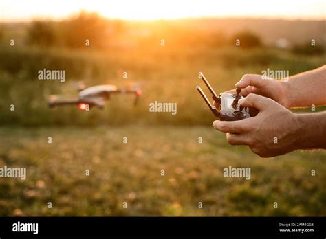 Man Holds Remote Controller With His Hands While Copter Is Flying On Background Drone Hovers