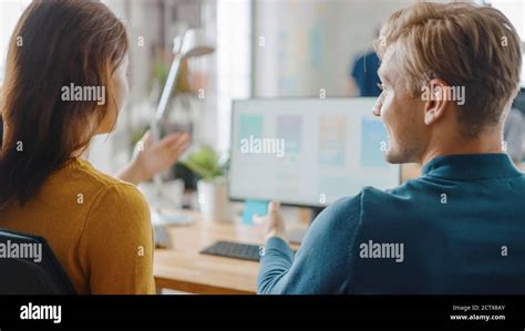 Two Mobile Software Developers Work On Desktop Computer They Discuss Smartphone Application