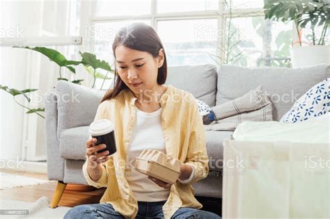 아시아 여성은 집에서 쓰레기를 분리합니다 젊은 여성은 플라스틱 종이 알루미늄 캔 음식 용기를 분류하고 재활용하여 아파트 거실의 쓰레기통에 넣습니다 가정에서의 재활용과 지속