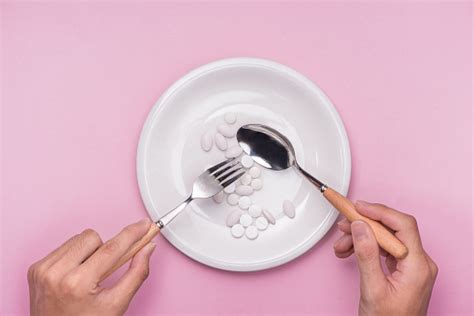 핑크 배경 위에 약 접시 위에 포크와 나이프를 들고 식탁에 남자의 손의 최고 볼 수 있습니다 0명에 대한 스톡 사진 및 기타