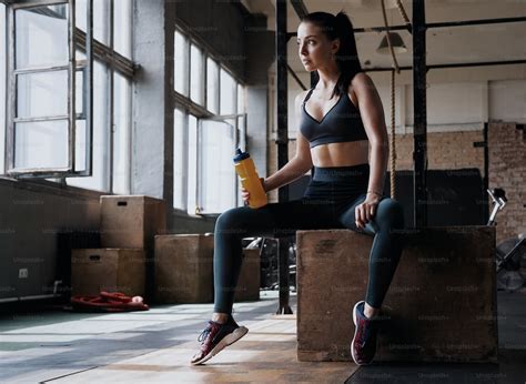 운동 후 체육관에서 상자에 앉아 있는 피트니스 여성 체육관에서 운동을 한 후 휴식을 취하는 여성 운동 선수 사진 Unsplash의 운동 이미지