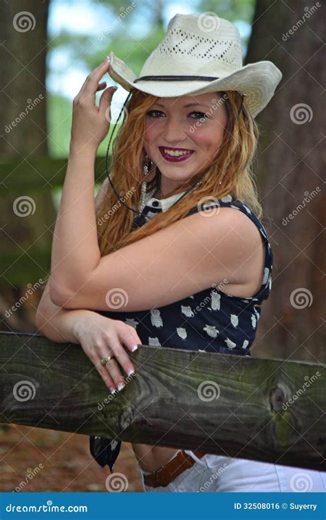 Προκλητικό Cowgirl θέτει το ξύλινο καπέλο κάουμποϋ φρακτών Στοκ Εικόνες