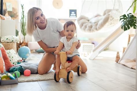 엄마와 작은 딸은 놀이방에서 시간을 보낸다 나무 스쿠터에 어린 소녀 모성 간호 사랑 개념 2명에 대한 스톡 사진 및 기타 이미지 Istock