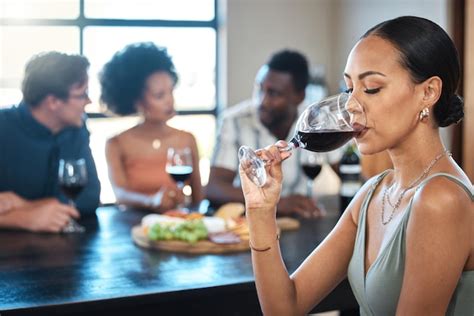 Premium Photo A Woman Drinking A Glass Of Wine At A Dinner Table With