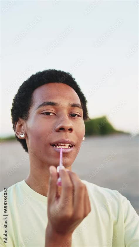 Vertical Video Of A Beautiful Babe Non Binary Person Putting On Make Up And Lipstick On A Sunny
