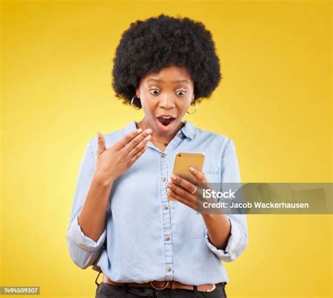 전화 놀라움 그리고 노란색 배경에 고립된 스튜디오에 있는 흑인 여성의 와우 충격 핸드폰 스마트폰으로 놀란 여성 소셜 미디어에서 좋은 소식 복권 당첨 또는 대회 당첨