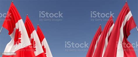캐나다와 라트비아의 국기는 파란색 배경의 깃대에 있습니다 텍스트를 위한 위치입니다 6 개의 깃발 오타와 단풍나무 리가 3d