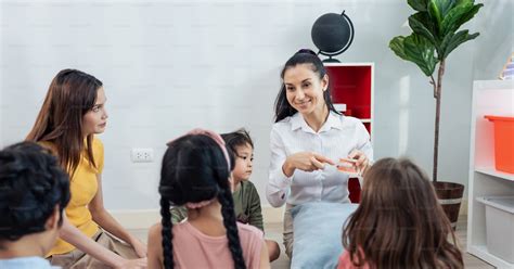 학교에서 혼혈 아이들을 가르치는 아시아의 아름다운 젊은 여성 교사 매력적인 여성 강사 마스터가 유치원 교실에서 재미있는 활동으로 어린이 학생을 설명하고 교육합니다 사진