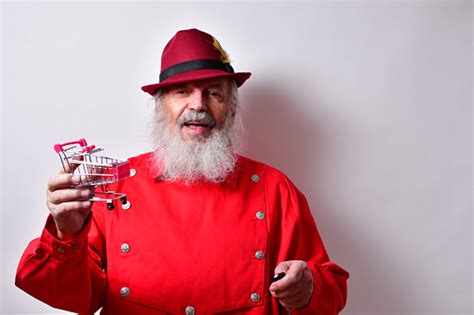 빨간 턱받이 셔츠와 중절모 모자를 쓴 은퇴한 미국 남성이 미니어처 쇼핑 카트를 들고 있다 고객에 대한 스톡 사진 및 기타 이미지 고객 구매 남자 Istock