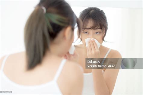 아름 다운 초상화 젊은 아시아 여자 미소 와 함께 피부 관리 화장품 사용 기름 얼룩 종이 얼굴에 거울을 보고 뷰티 아시아 여자