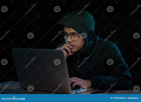 Asian Hacker Hacking Computer Network With Laptop In Dark Cyber