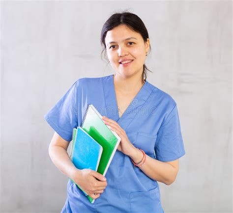 Estudiante De Medicina Sonriente Sostiene Libros De Texto Con Notas De Conferencia Foto De