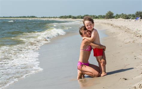 La Más Vieja Hermana Abraza A Su Hermano Menor En La Playa Con Las