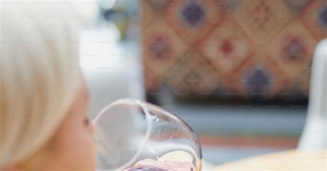 전문 성숙한 여성 소믈리에가 와인 잔에서 빨간 카베르네를 맛보면서 맛을 평가합니다 사진 Unsplash의 사람 이미지