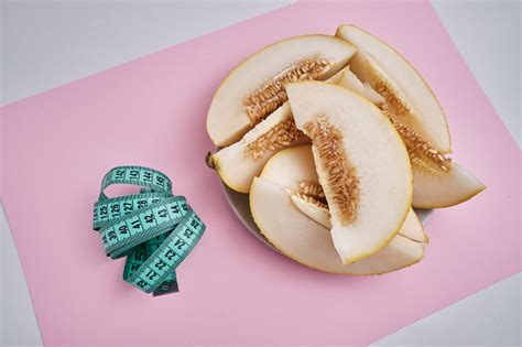 밝은 배경과 달콤한 멜론에 녹색 측정 테이프 길이와 부피를 측정하기 위한 도구입니다 적절한 영양의 개념 의류 산업의 줄자 또는 인체의 부피 0명에 대한 스톡 사진 및 기타