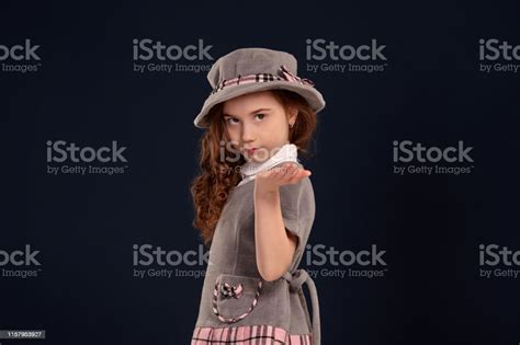 검은 배경에 포즈를 취하는 길고 곱슬 머리로 사랑스러운 어린 아이의 스튜디오 샷 갈색 머리에 대한 스톡 사진 및 기타 이미지