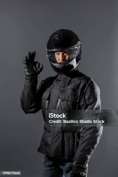 보호 모터 검은 옷을 입은 남자는 스튜디오에서 확인 사인을하고 있습니다 자동차 경주 선수에 대한 스톡 사진 및 기타 이미지 자동차 경주 선수 오토바이 40 44세