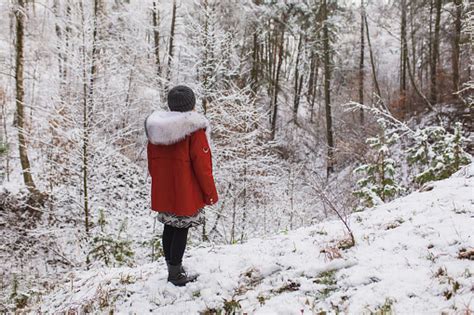겨울 숲에서 모피와 모자를 쓴 빨간 재킷을 입은 빨간 머리 여자 휴가를 즐기는 예쁜 여자 자연의 소녀 행복을 느껴보세요 흰 서리와 나무에 눈 12월에 대한 스톡 사진 및
