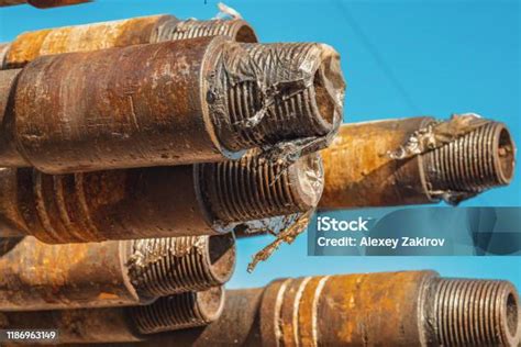 오일 드릴 파이프 녹슨 드릴 파이프는 우물 섹션에서 드릴링되었습니다 다운홀 드릴링 장비 갑판에 파이프를 누워 석유 및 가스 창고의 안뜰에 누워 드릴 파이프의 껍질의 보기 0