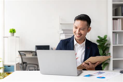 금융 그래프 차트 마케팅 정보 계획을 작성하는 아시아 사업가 책상에서 노트북을 사용하여 계산 및 분석을 위해 재무 문서 스프레드시트를 읽는 남성의 손 저축에 대한 스톡 사진