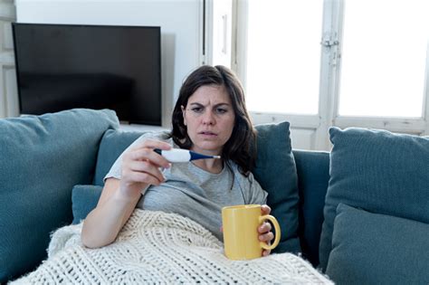 의료 및 의학 집에서 소파에 누워 아픈 여 자가 피로와 불안을 느끼는 온도계로 고온의 두통 아픈 코를 확인 하 고 직장에 갈 수