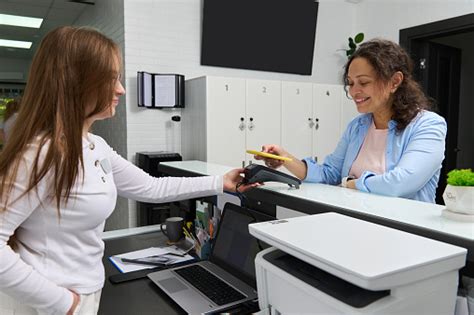 Nfc 기술로 비접촉식 신용 카드로 지불하는 고객의 손 여성 보유 신용 카드와 바 카운터에서 신용 카드 리더 기계와 바텐더 손에 집중하십시오 고객에 대한 스톡 사진 및 기타