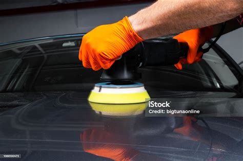 자동차 폴란드어 왁 스 작업자 연마 하기 전에 적용 보호 테이프를 손 버프 하 고 차를 연마입니다 자동차 적입니다 남자 손에서 폴 리 셔를 보유 하 고 차를 닦는다 연마 용