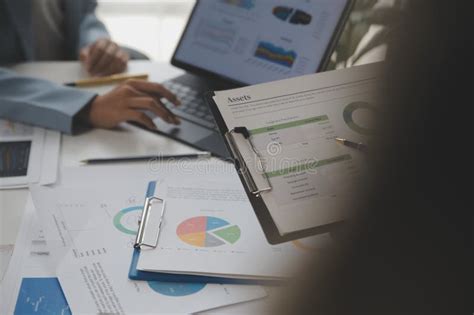 Close Up Of Business Team Analyzing Income Charts And Graphs With