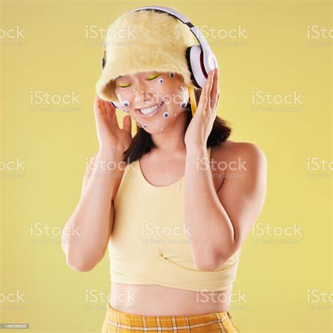 음악 헤드폰 메이크업 스튜디오에 있는 여자는 노란색 배경에 고립되어 있다 아이 스티커 자유 기술 및 행복한 여성 모델 듣기 라디오 팟 캐스트 및 오디오 노래 즐기기 및