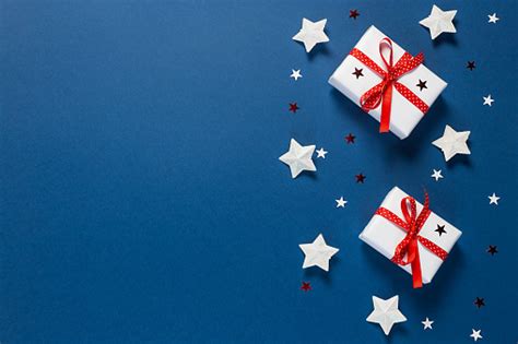 크리스마스 배경 흰색 선물 상자는 파란색에 별 모양의 빨간색 리본과 Xmas 장난감으로 묶여 있습니다 개념에 대한 스톡 사진 및