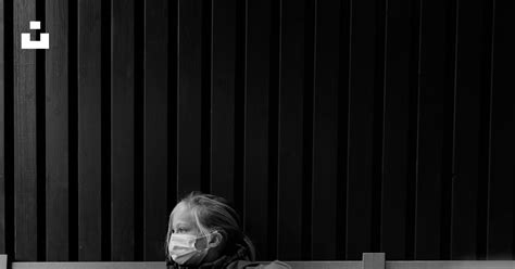 검은 재킷을 입은 여자가 흑백 줄무늬 벽 옆에 서 있다 사진 Unsplash의 무료 검정 이미지