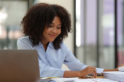 사무실 책상에서 노트북과 문서를 가지고 일하는 매력적인 아프리카계 미국인 사업가의 초상화 20 24세에 대한 스톡 사진 및 기타 이미지 20 24세 경영자 금융