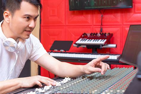 아시아 음악 프로듀서 사운드 엔지니어의 초상화는 가수와 통신하고 스튜디오에서 오디오 믹싱 콘솔에서 작업하는 동안 녹음 및 음악 제작 개념 Brand Name Video