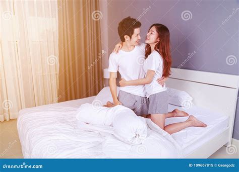 Happy Young Attractive Couple Hugging On Bed In Bedroom Stock Image