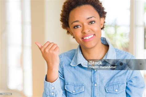 젊은 아름 다운 아프리카 계 미국인 여자 행복 한 얼굴 찾고 엄지 손가락으로 측면을 가리키는 미소 가리키기에 대한 스톡 사진 및 기타 이미지 Istock