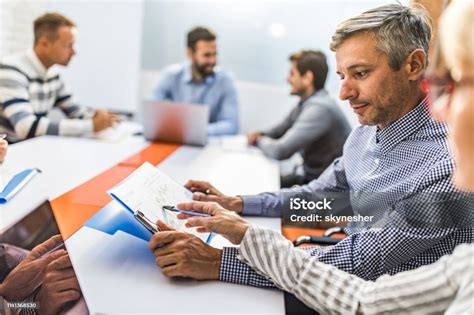 사무실에서 회의 중에 보고서 작업을 하는 비즈니스 동료 모임에 대한 스톡 사진 및 기타 이미지 모임 읽기 전문 직업 Istock