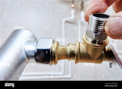 Close Up Of Hand Installing Reducer On Brass T Fitting Part Of